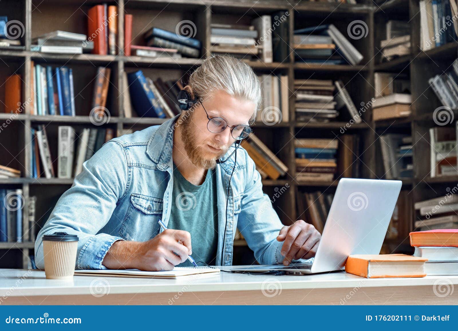 Focused Man Student Wear Headset Study Online Make Notes in Library ...