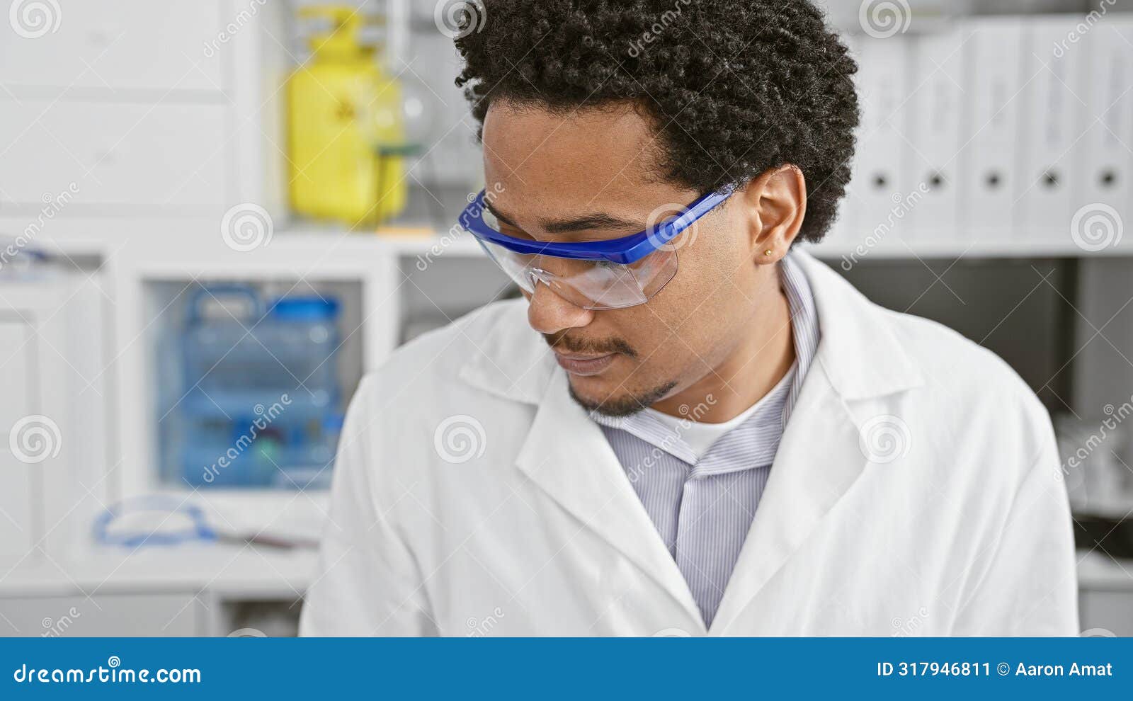 Focused Young Man Working in a Laboratory Wearing Safety Goggles and a ...