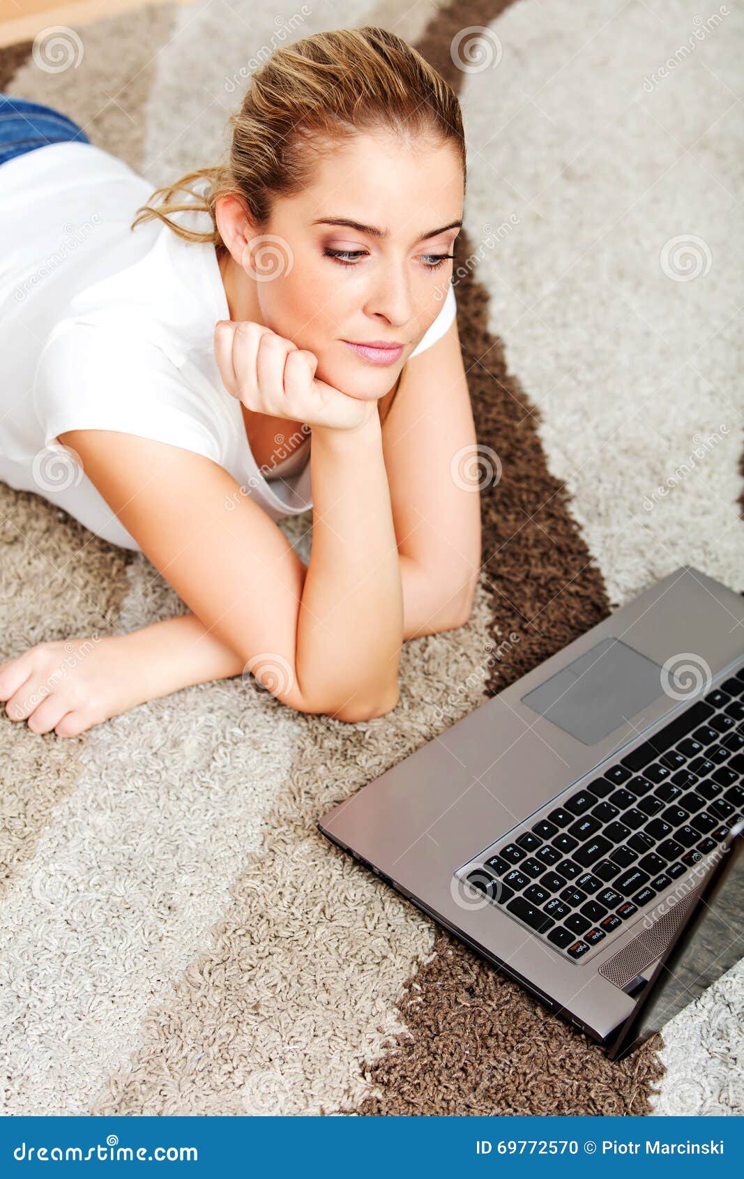 Focused Young Woman Using Laptop while Lying on Floor Stock Photo ...