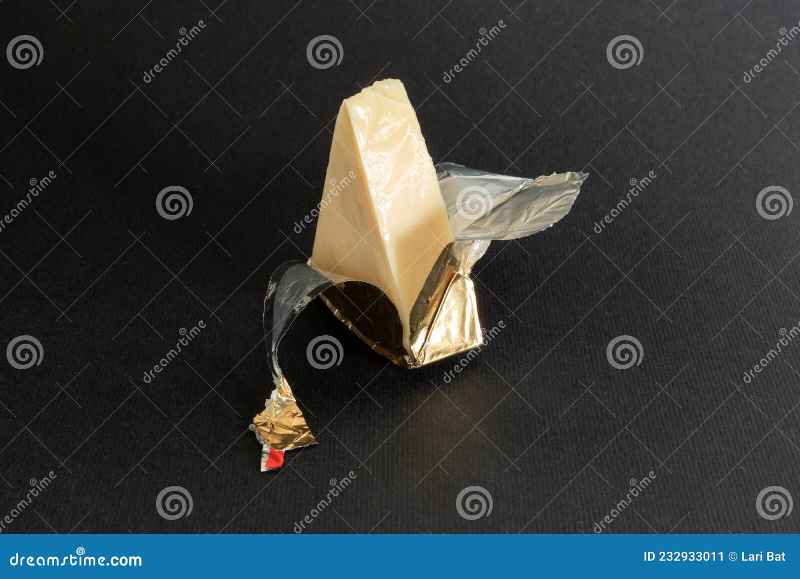 Foil Wrapped Processed Creame Cheese Slice on a Black Background. Small ...