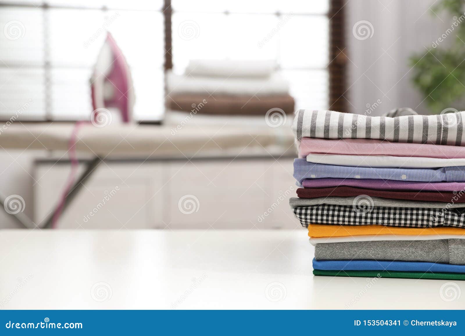 Folded Clean Clothes on Table Indoors. Laundry Day Stock Image - Image ...