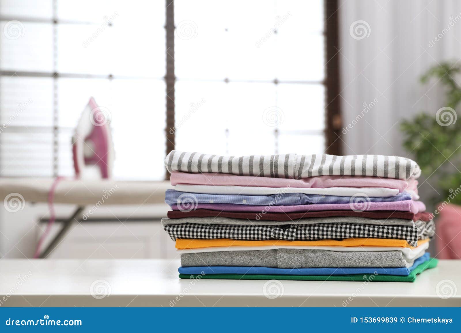 Folded Clean Clothes on Table Indoors. Laundry Day Stock Image - Image ...