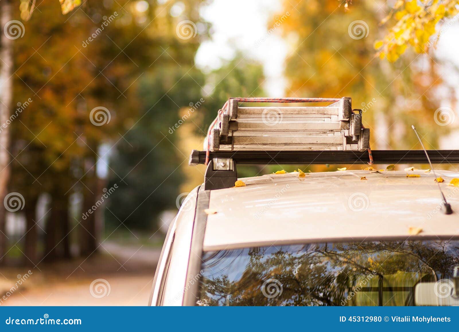 Folded Ladder Lies on Top of a White Car. Stock Photo - Image of aerial ...