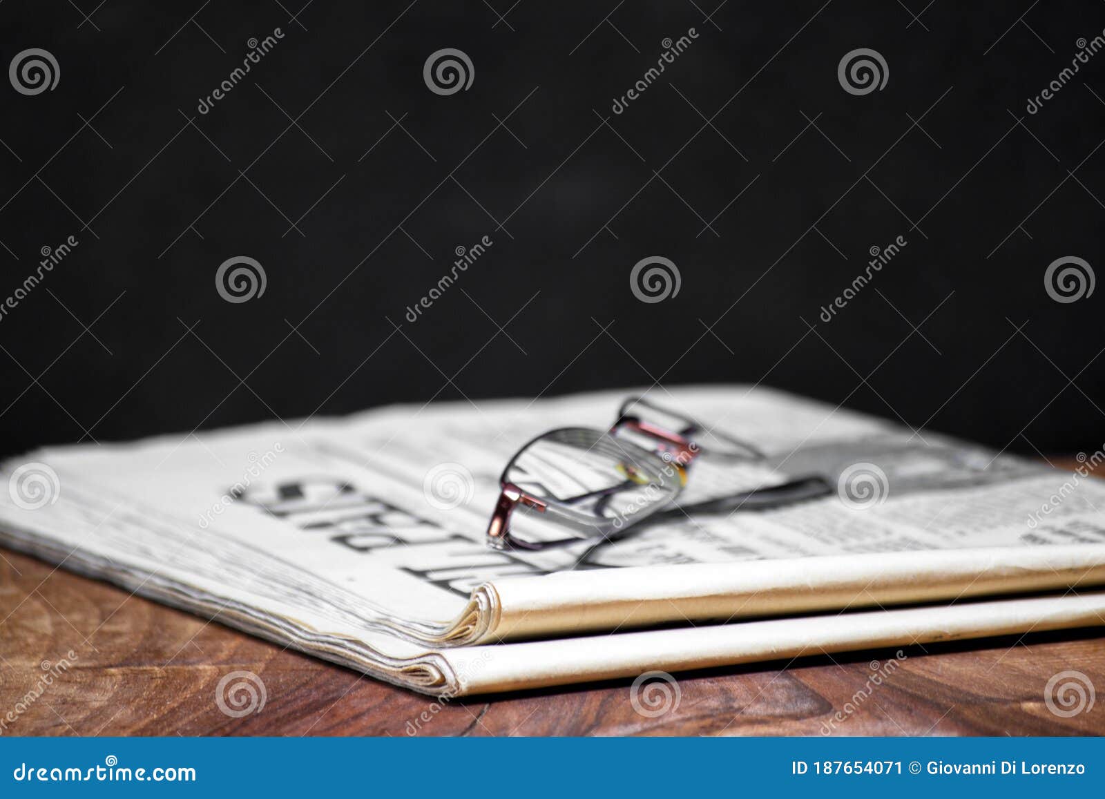 Folded Newspaper with a Pair of Reading Glasses on it Editorial Photo ...