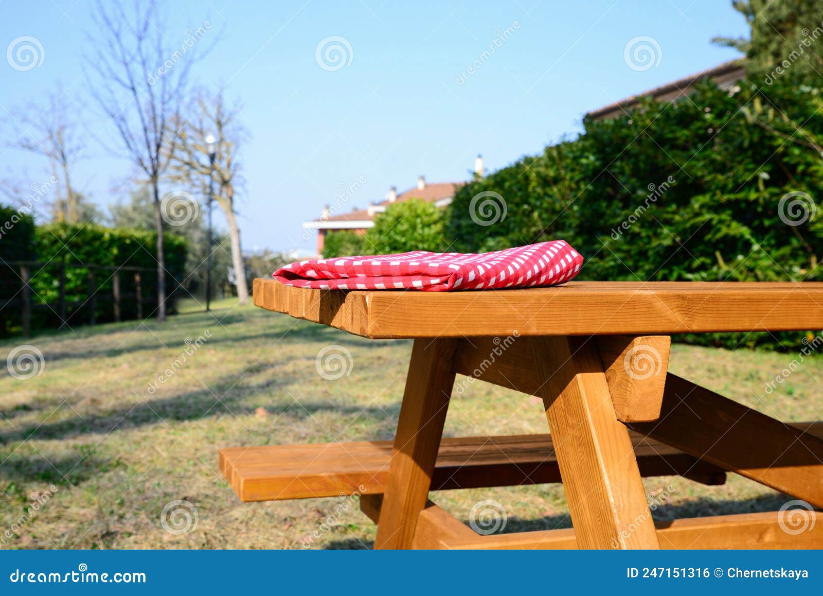 Folded Red and White Checkered Tablecloth on Wooden Picnic Table in ...