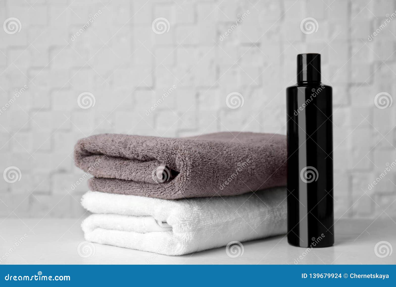 Folded Towels and Shampoo on Table Stock Photo - Image of copy ...