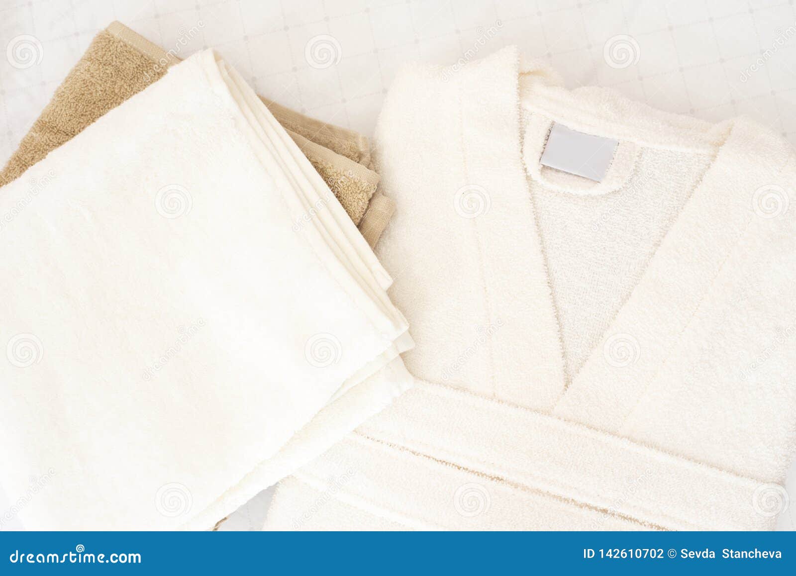 Folded White Bathrobe and Towels on Bed in Room Stock Photo - Image of ...
