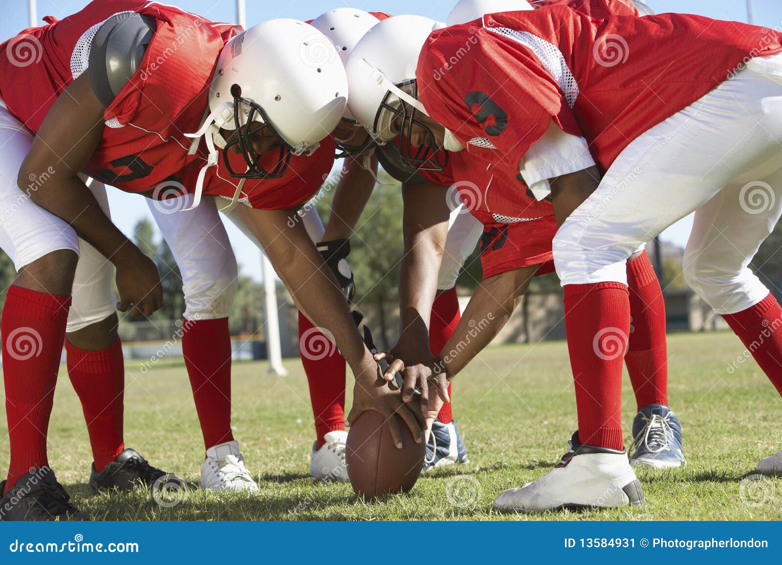 Football Players Around Ball Stock Image - Image of athlete, huddle ...
