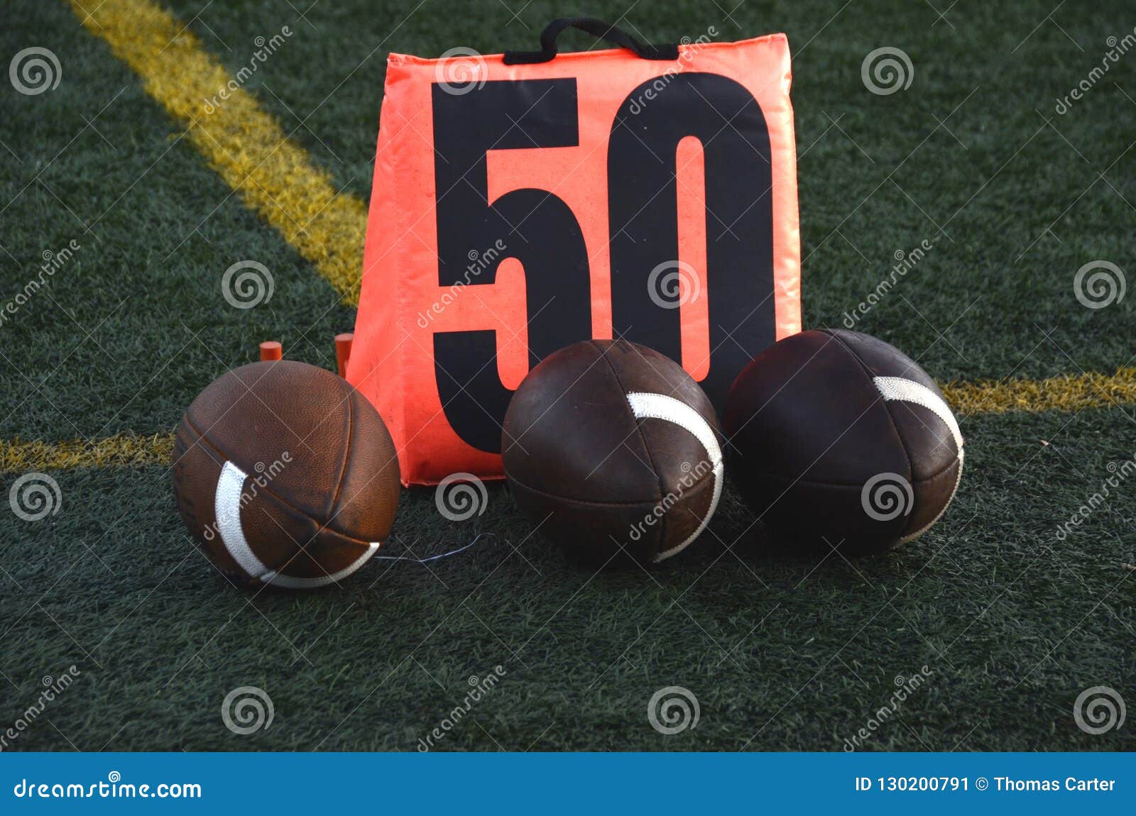 Footballs at 50 yard line stock image. Image of line - 130200791