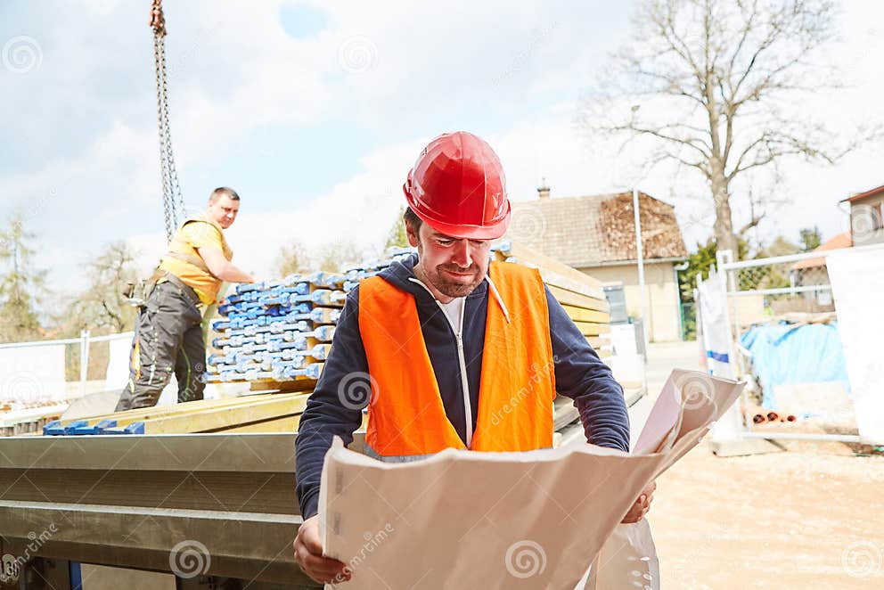 Foreman on Construction Site with Building Materials in the Background ...
