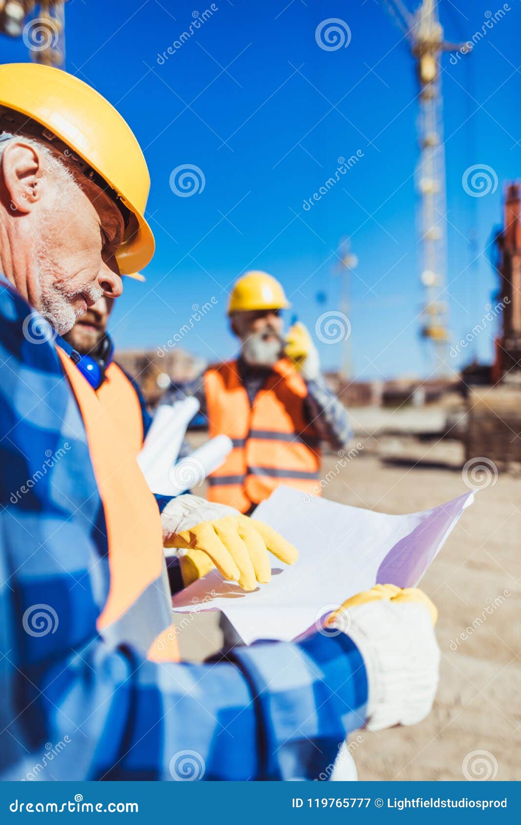Foreman Examining a Building Plan while Standing at Construction Site ...