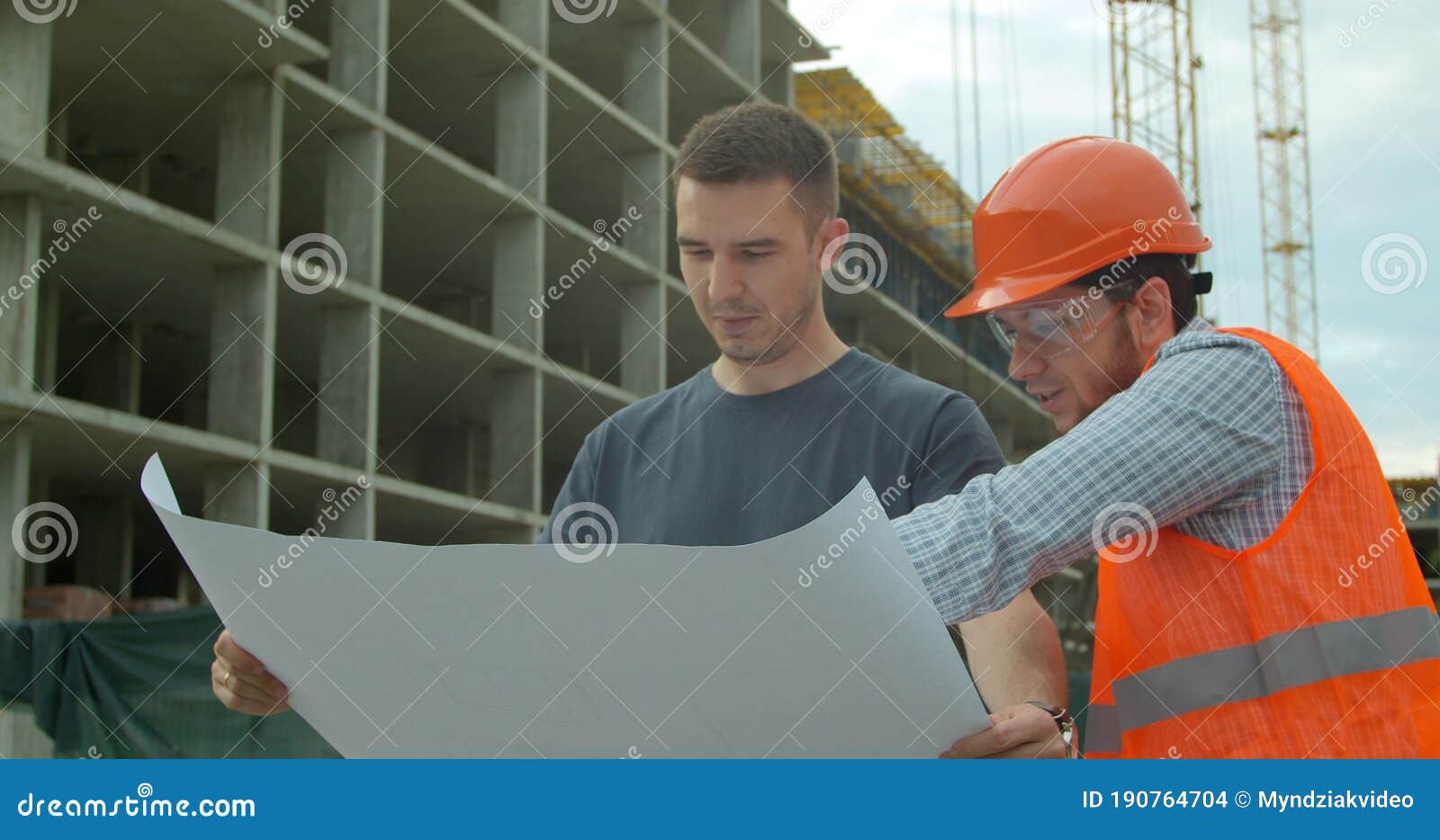 Foreman Expertising the Structure with Man Holding a Blueprints at the ...