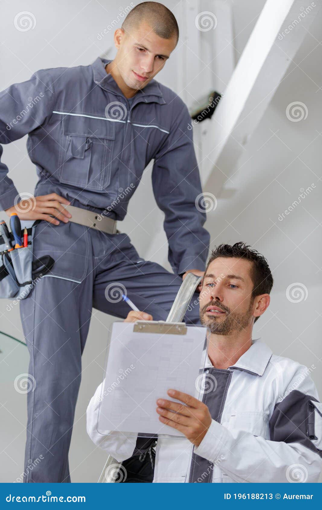 Foreman Giving Instructions To Apprentice on Stepladder Stock Image ...