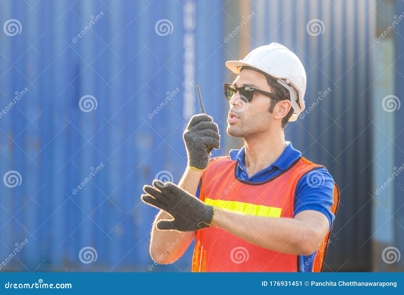 Foreman in Hardhat and Safety Vest Talks on Two-way Radio Control ...