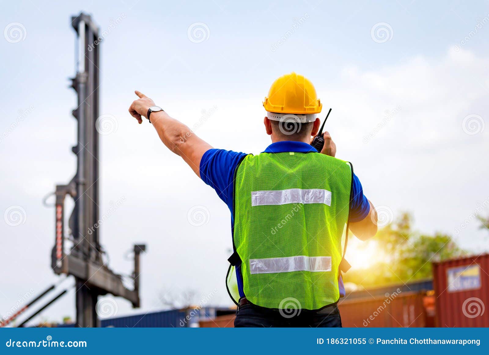 Foreman in Hardhat and Safety Vest Talks on Two-way Radio Control ...