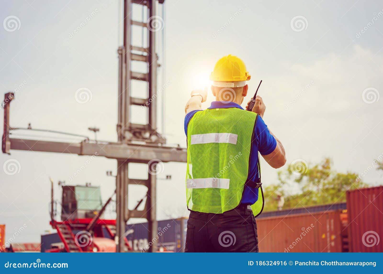 Foreman in Hardhat and Safety Vest Talks on Two-way Radio Control ...