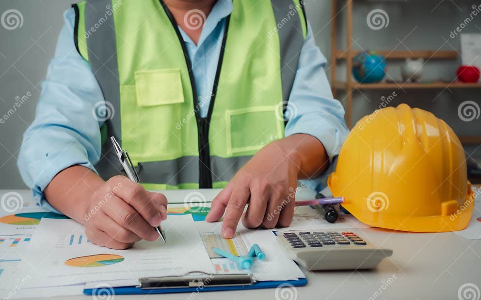 A Foreman Sits at a Desk in an Office, Calculating Costs, Planning ...