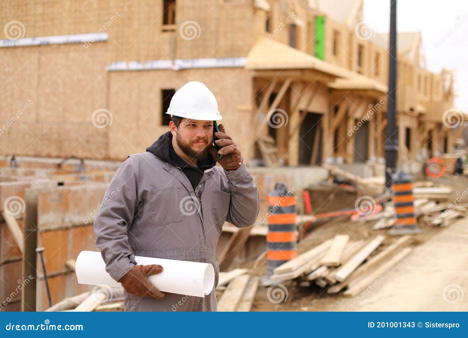 Foreman Speaking by Smartphone and Holding Drawing Plan at Construction ...