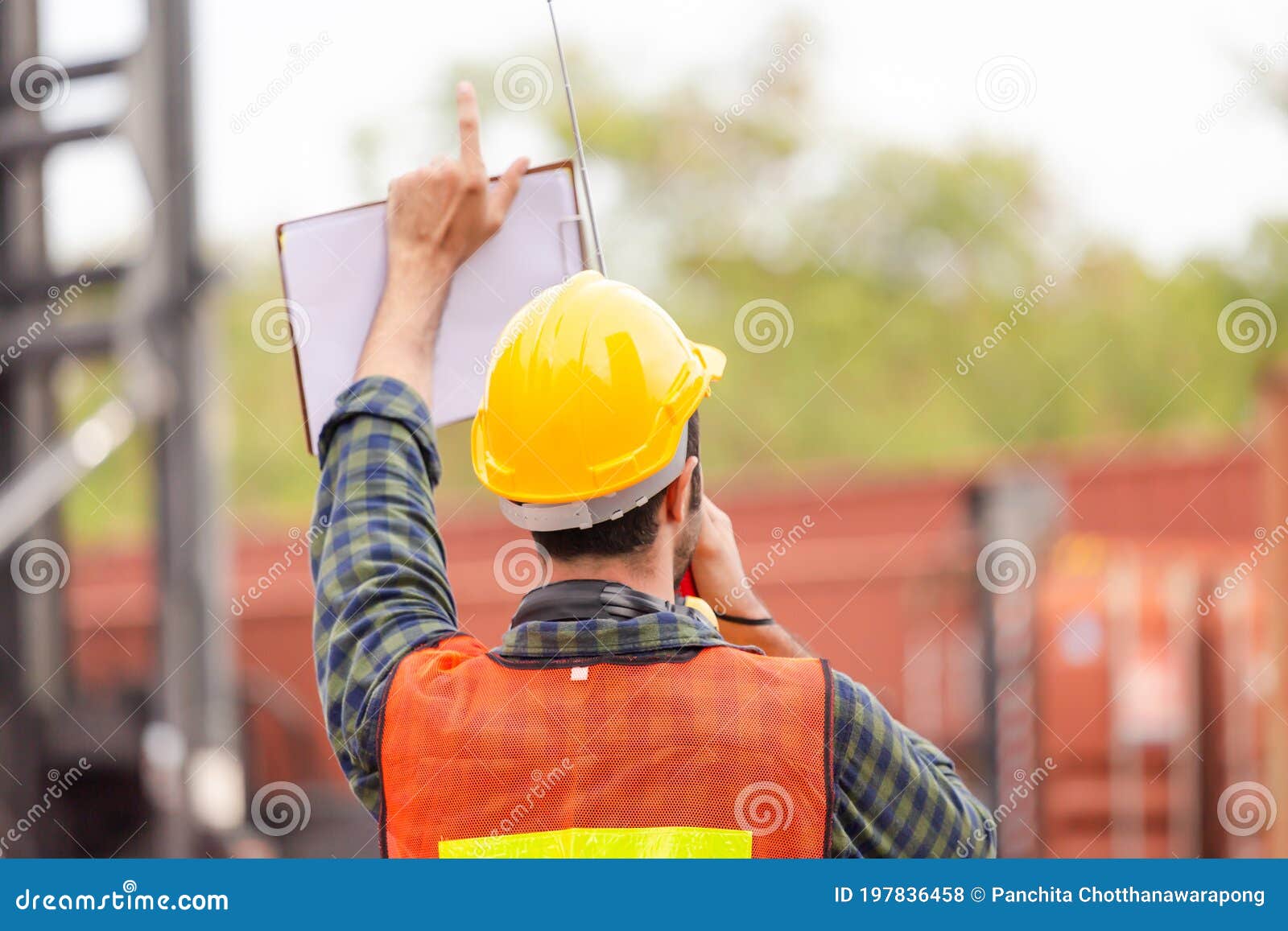 Foreman Worker in Hardhat and Safety Vest Talks on Two-way Radio ...