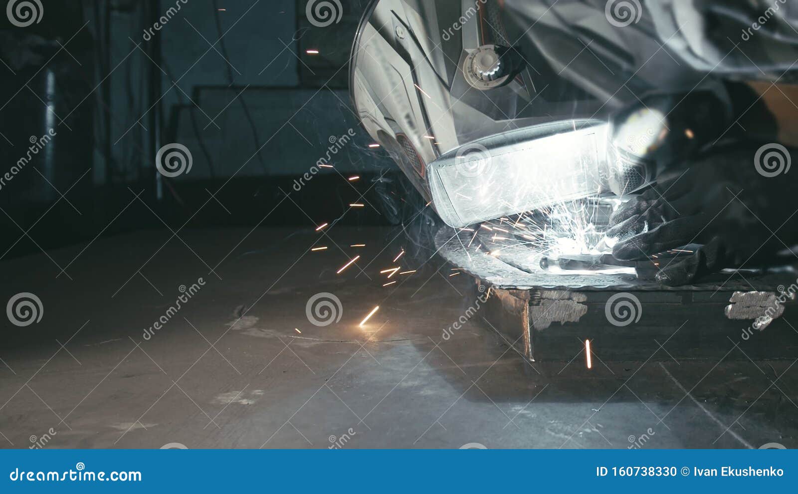 Forge Workshop. Smithy. Worker in a Welding Hood Helmet Welds a Part by ...
