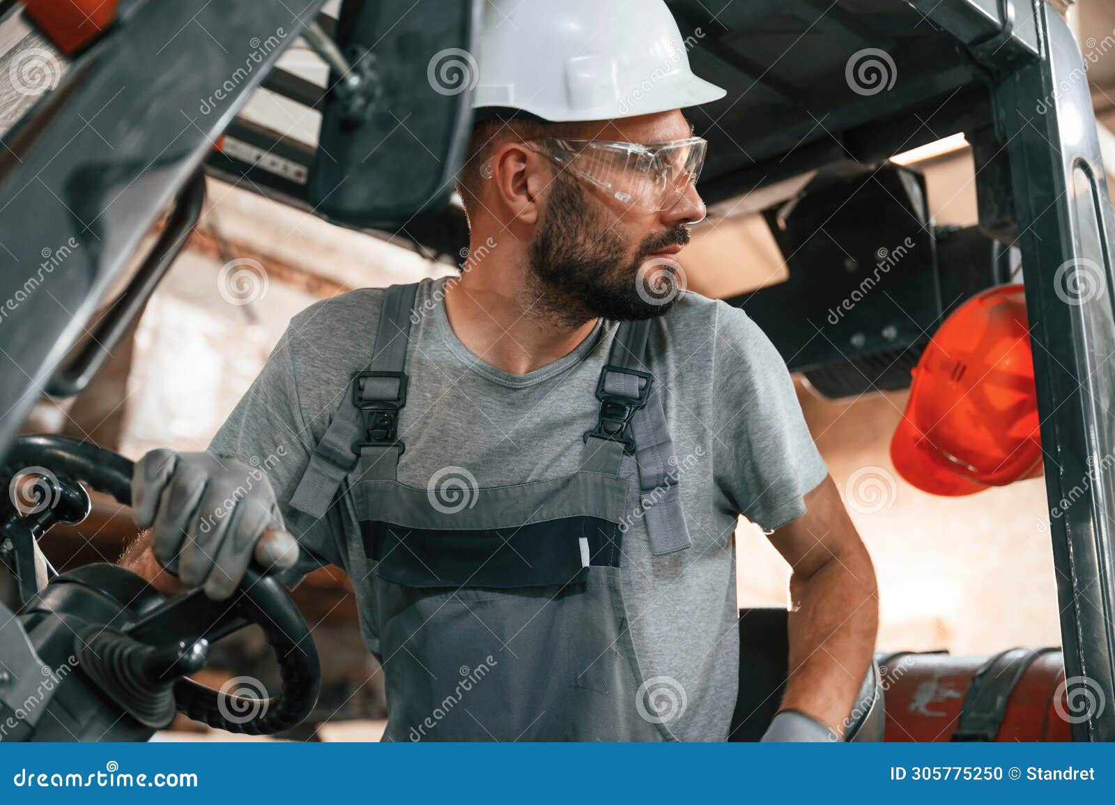 In the Forklift. Young Factory Worker in Grey Uniform Stock Photo ...