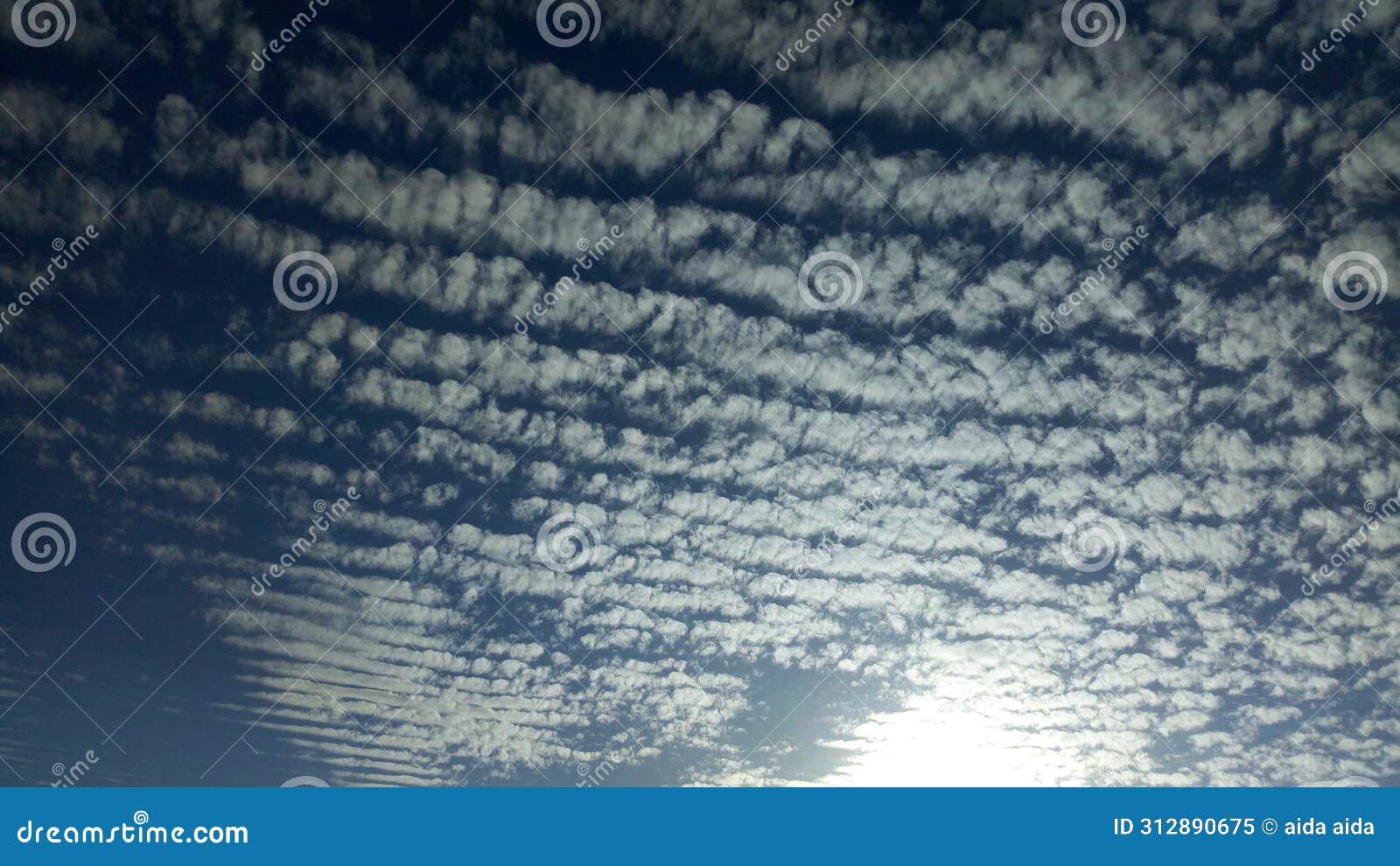 A Formation of White Clouds in the Form of Artistic Ripples in a Bright ...