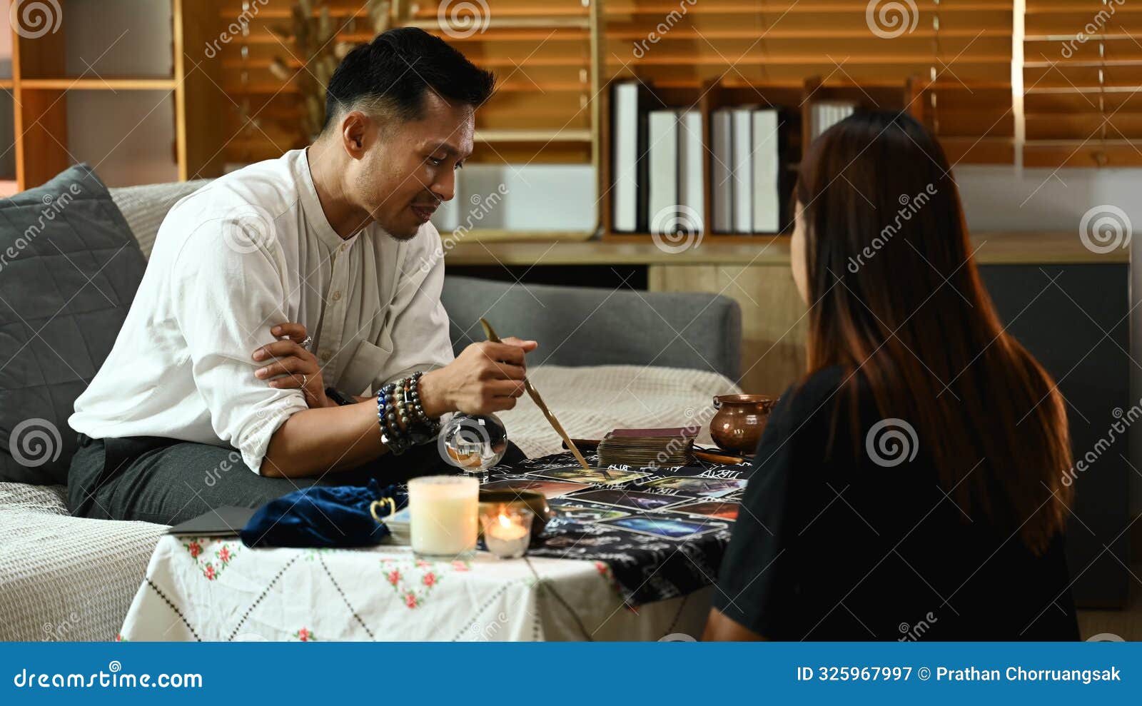 Fortune Teller during a Reading Session Talking To Client at Table with ...