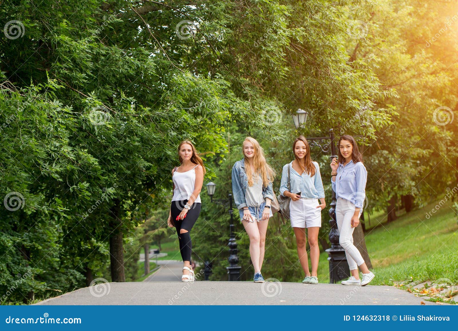 Four Attractive Young Women Talking Walking Together Stock Photo ...