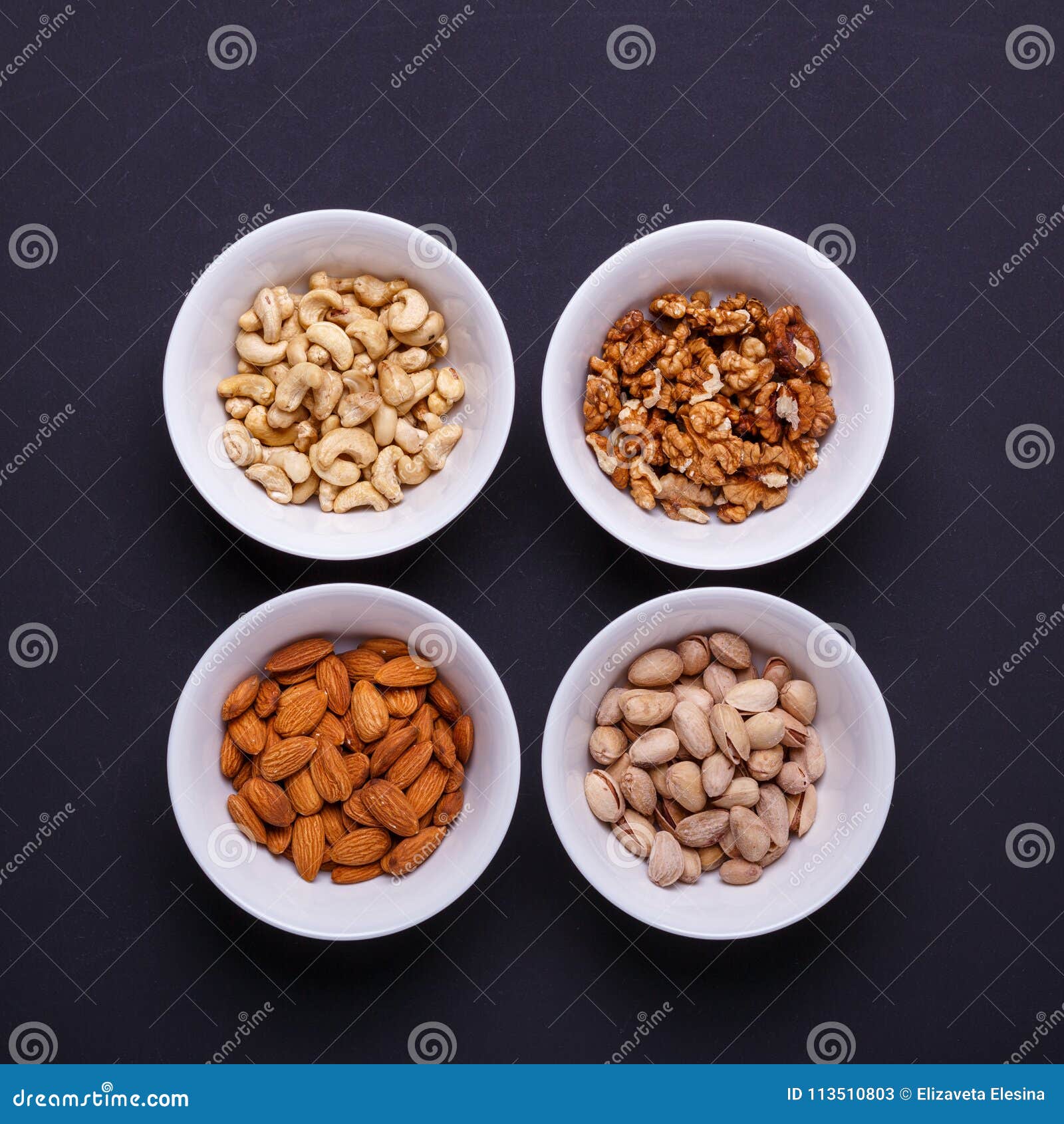 Four Bowls with Different Nuts on a Black Table Stock Image - Image of ...