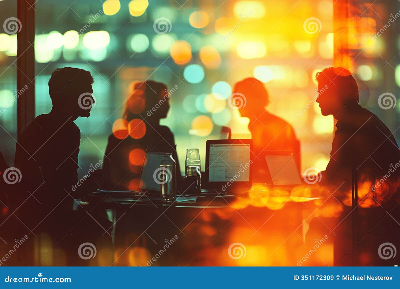Four Business People Having a Meeting at Night with Laptops Using ...