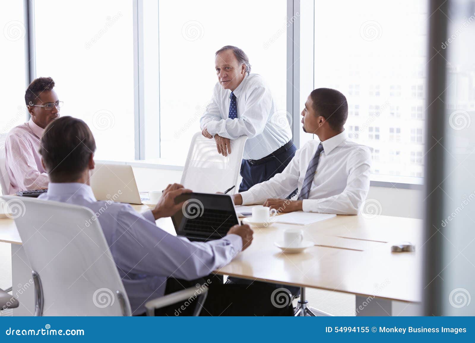 Four Businessmen Having Meeting Around Boardroom Table Stock Image ...