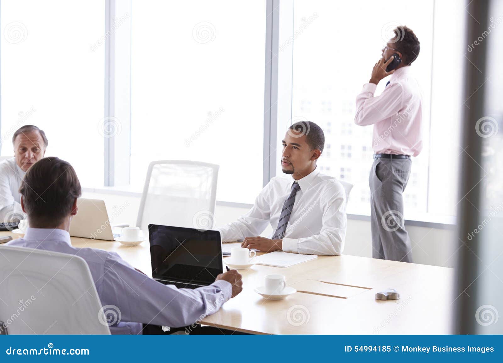 Four Businessmen Having Meeting Around Boardroom Table Stock Image ...