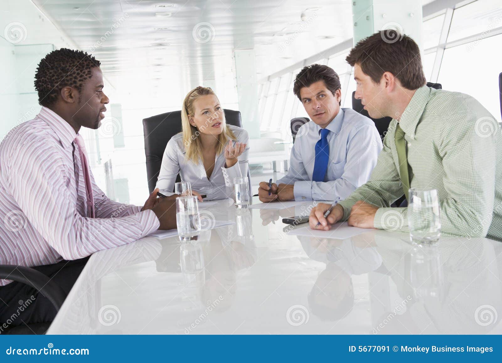 Four Businesspeople in a Boardroom Talking Stock Image - Image of room ...