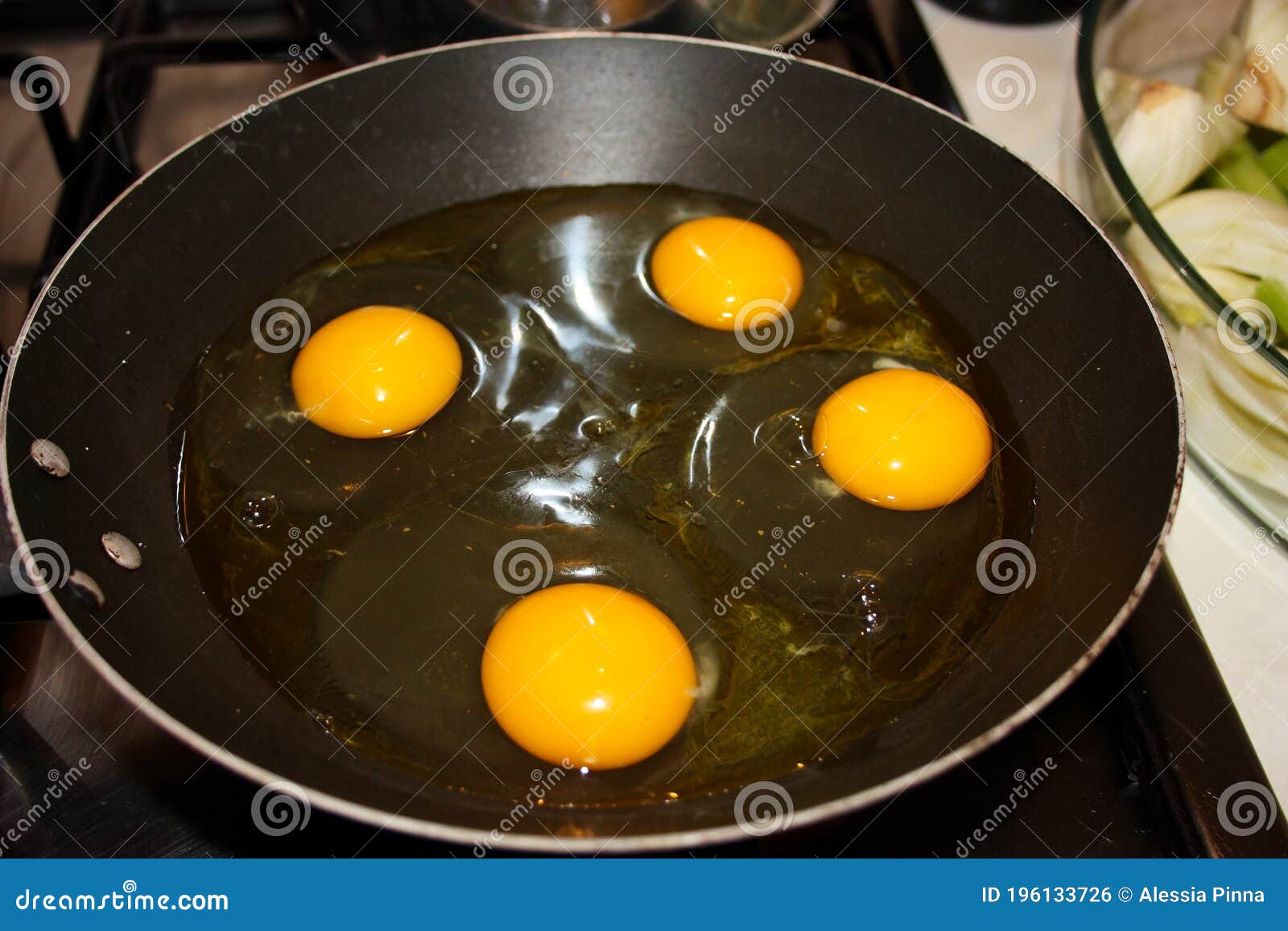 Four Chicken Eggs Being Cooked in a Round Black Pan Stock Photo - Image ...