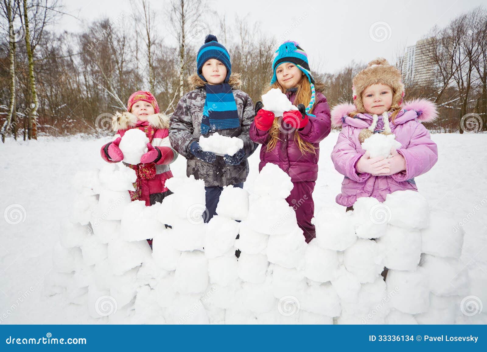 Four Children Stand Behind Wall Made from Snow Bricks Stock Photo ...