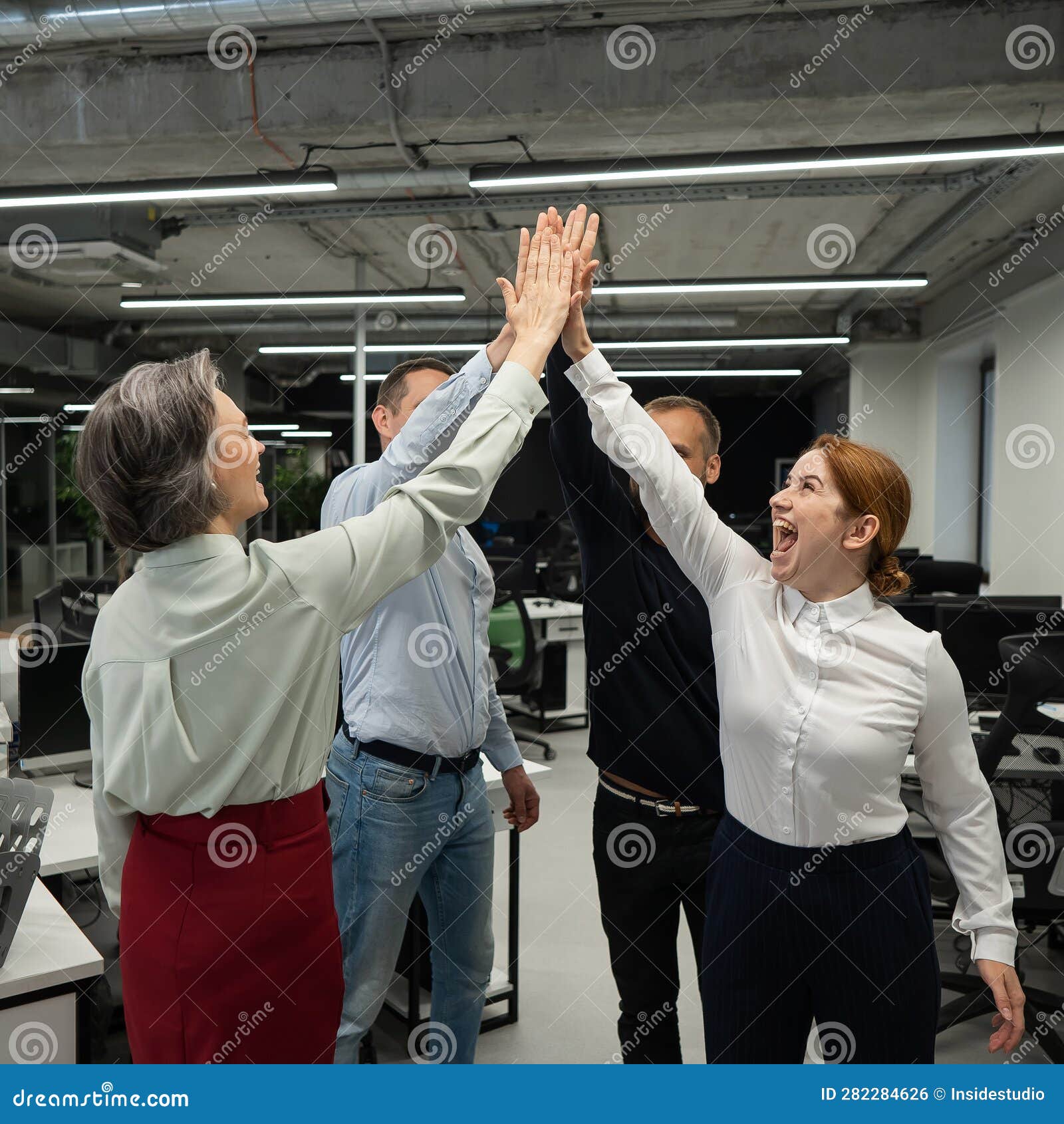 Four Co-workers Give a High Five in the Office. Stock Photo - Image of ...