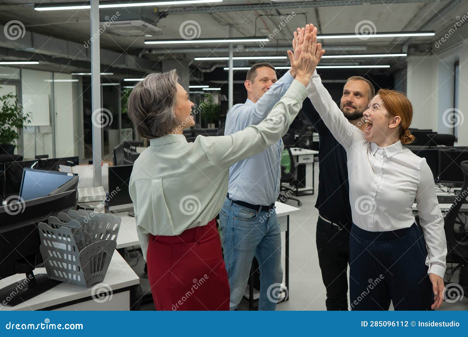 Four Co-workers Give a High Five in the Office. Stock Photo - Image of ...