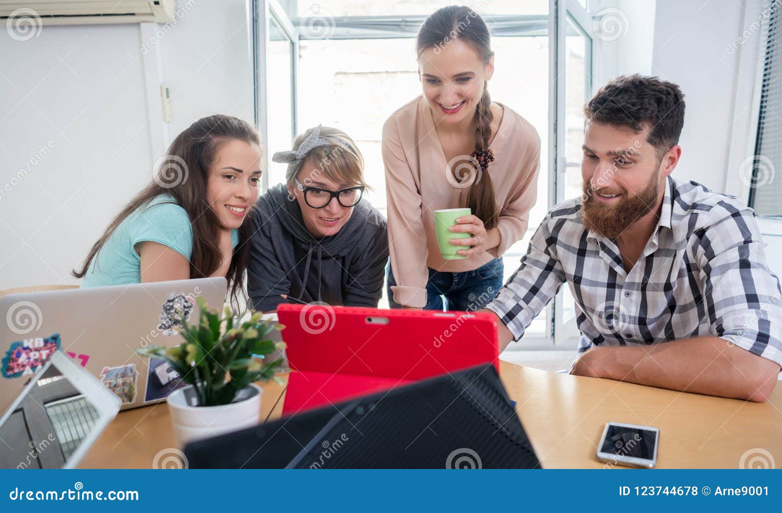 Four Co-workers Watching a Business Presentation in a Modern Shared ...