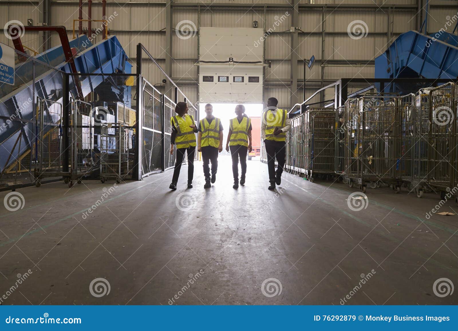 Four Colleagues Walking into a Warehouse, Wide View Stock Image - Image ...