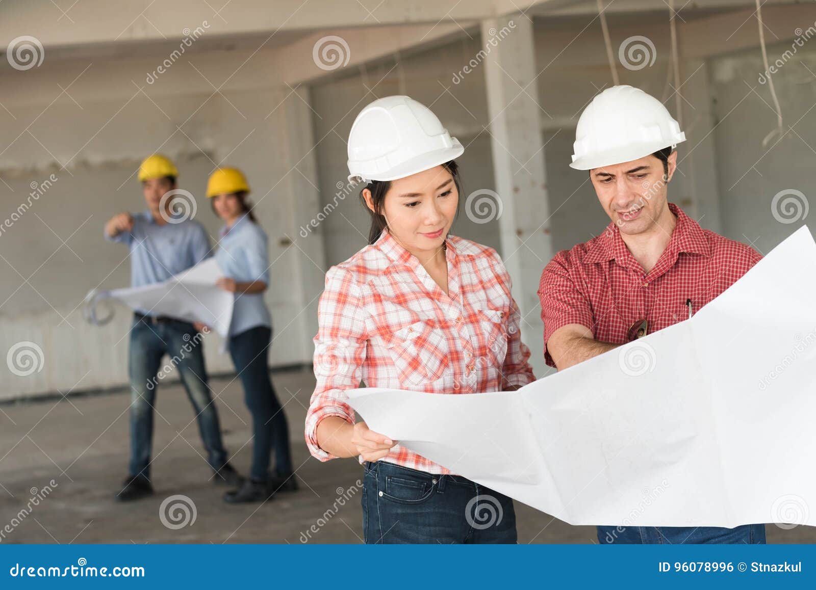 Four Construction Engineer Working in Side Building Plan for Renovation ...