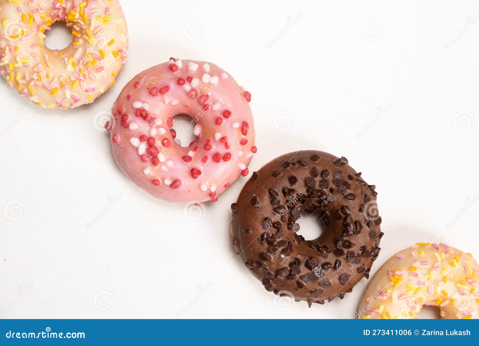 Four Donuts in a Row - White, Pink and Chocolate on a White Background ...