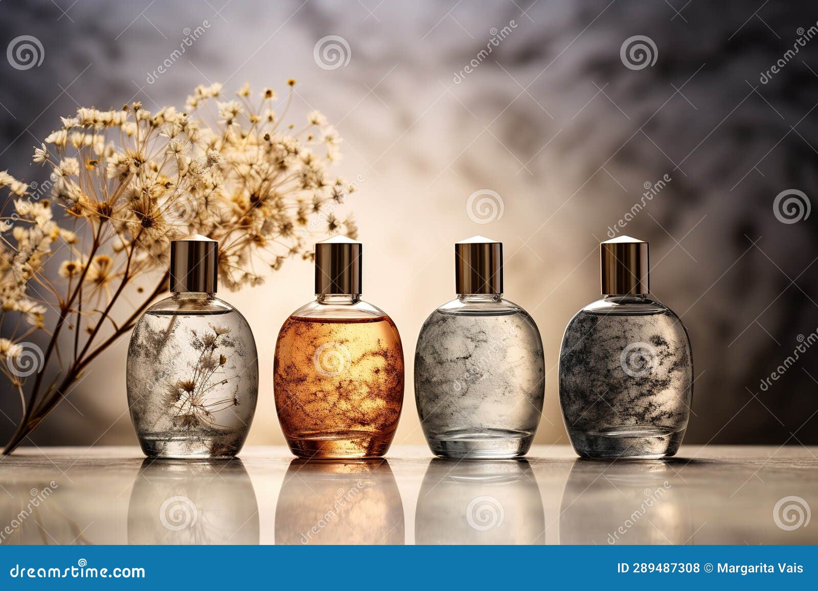 Four Elegant Glass Perfume Bottles on a Gray Illuminated Background ...