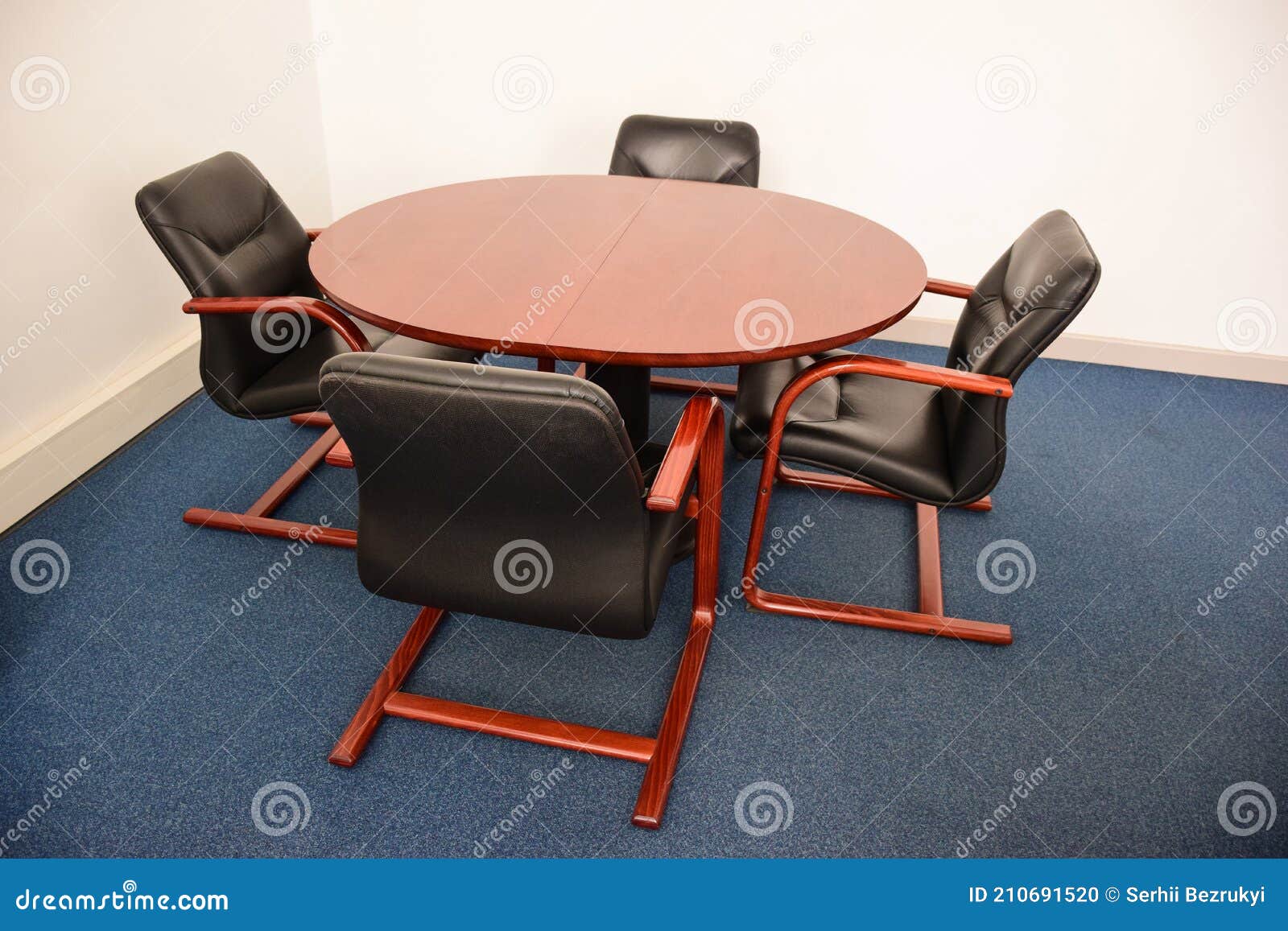 Four Empty Leather Office Chairs Sit Around a Round Table Stock Photo ...