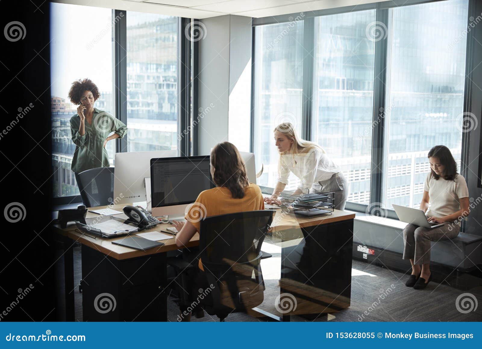 Four Female Creative Colleagues Working Together in an Office, Seen ...