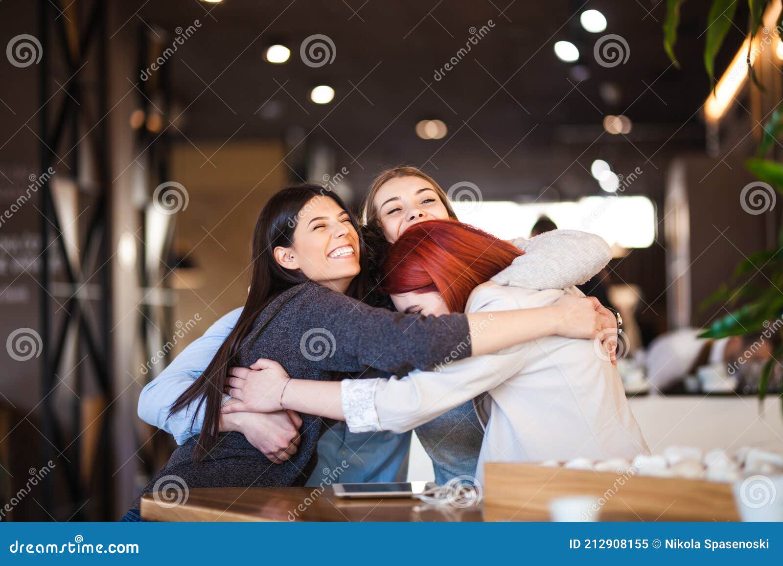 Four Friends at a Cafe Celebrating and Hugging. Successful Young People ...