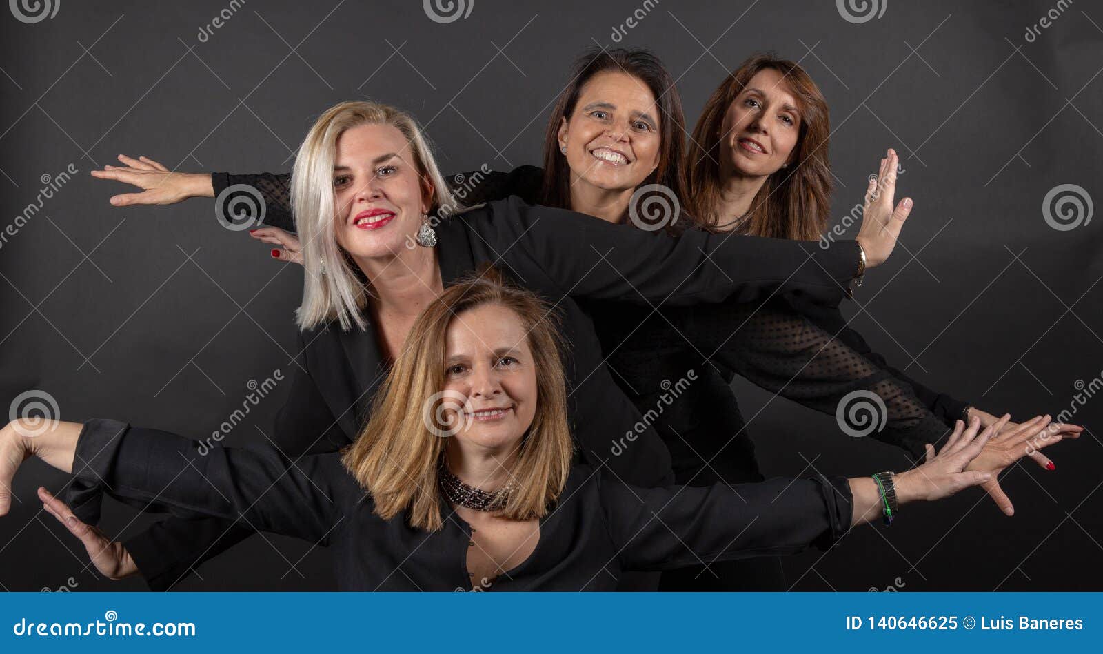 Four Friends Posing in a Studio with a Black Background Stock Image ...