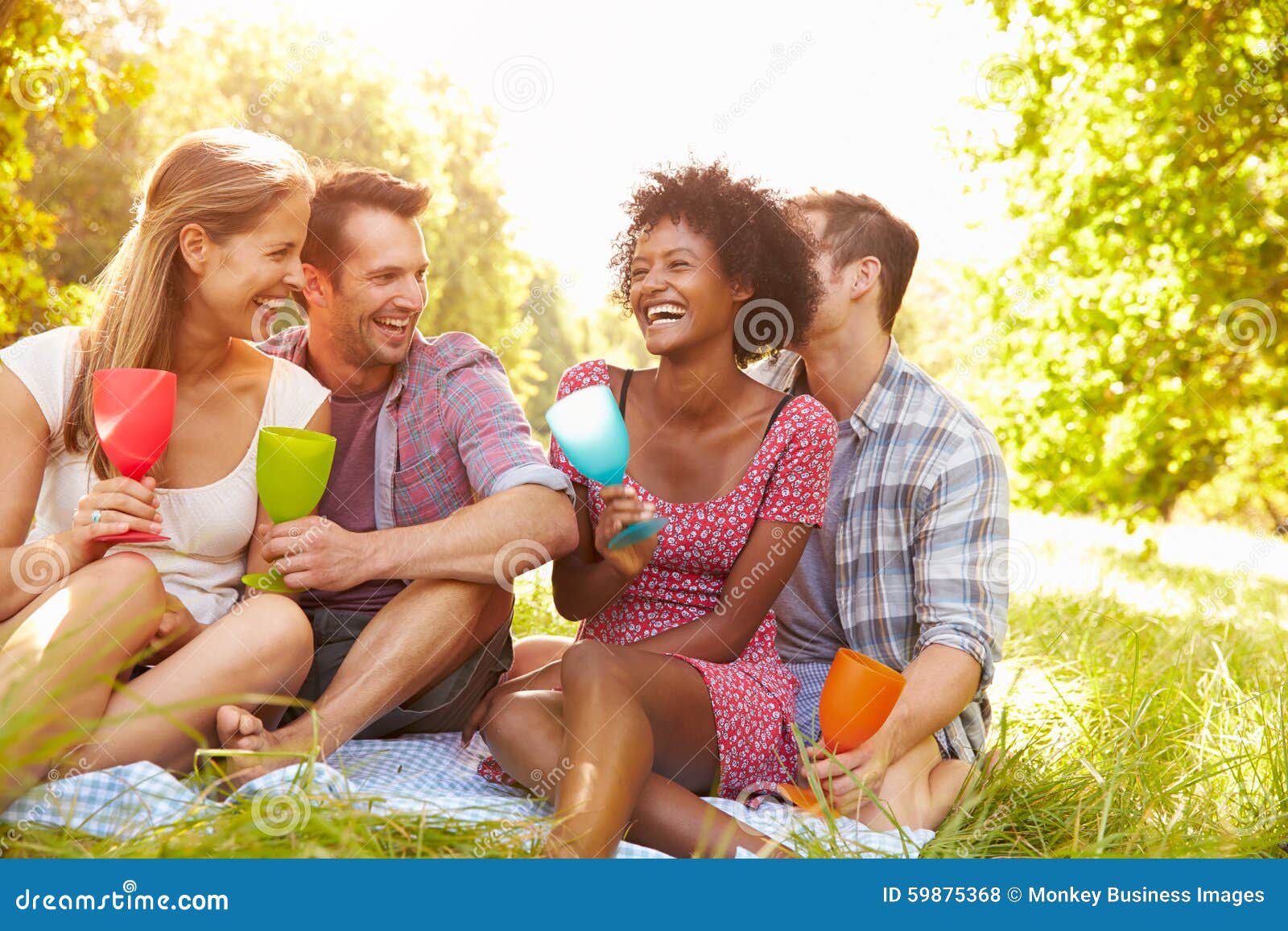 Four Friends Relax Together Drinking in the Countryside Stock Photo ...