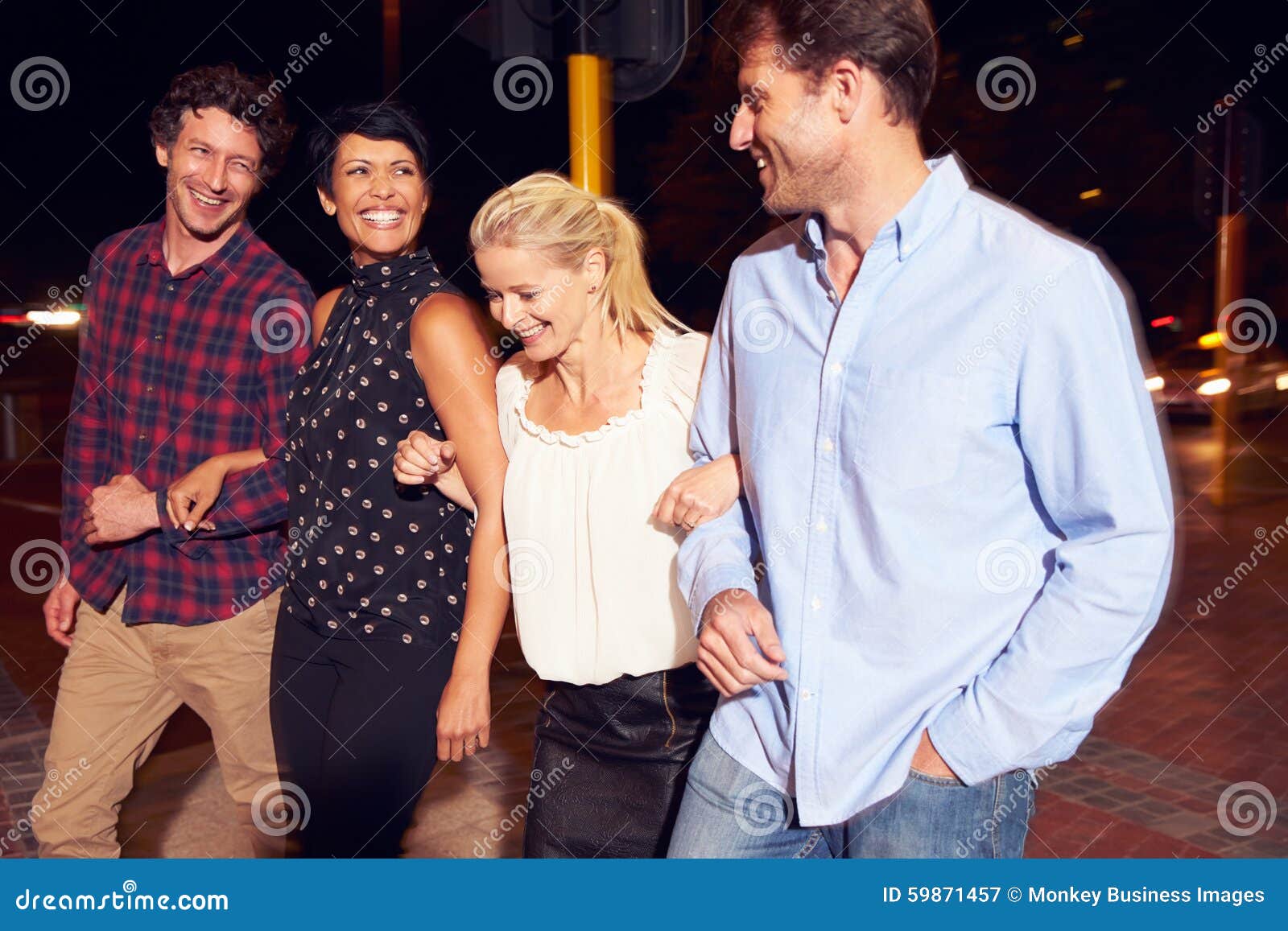 Four Friends Walking through Town Together at Night Stock Image - Image ...