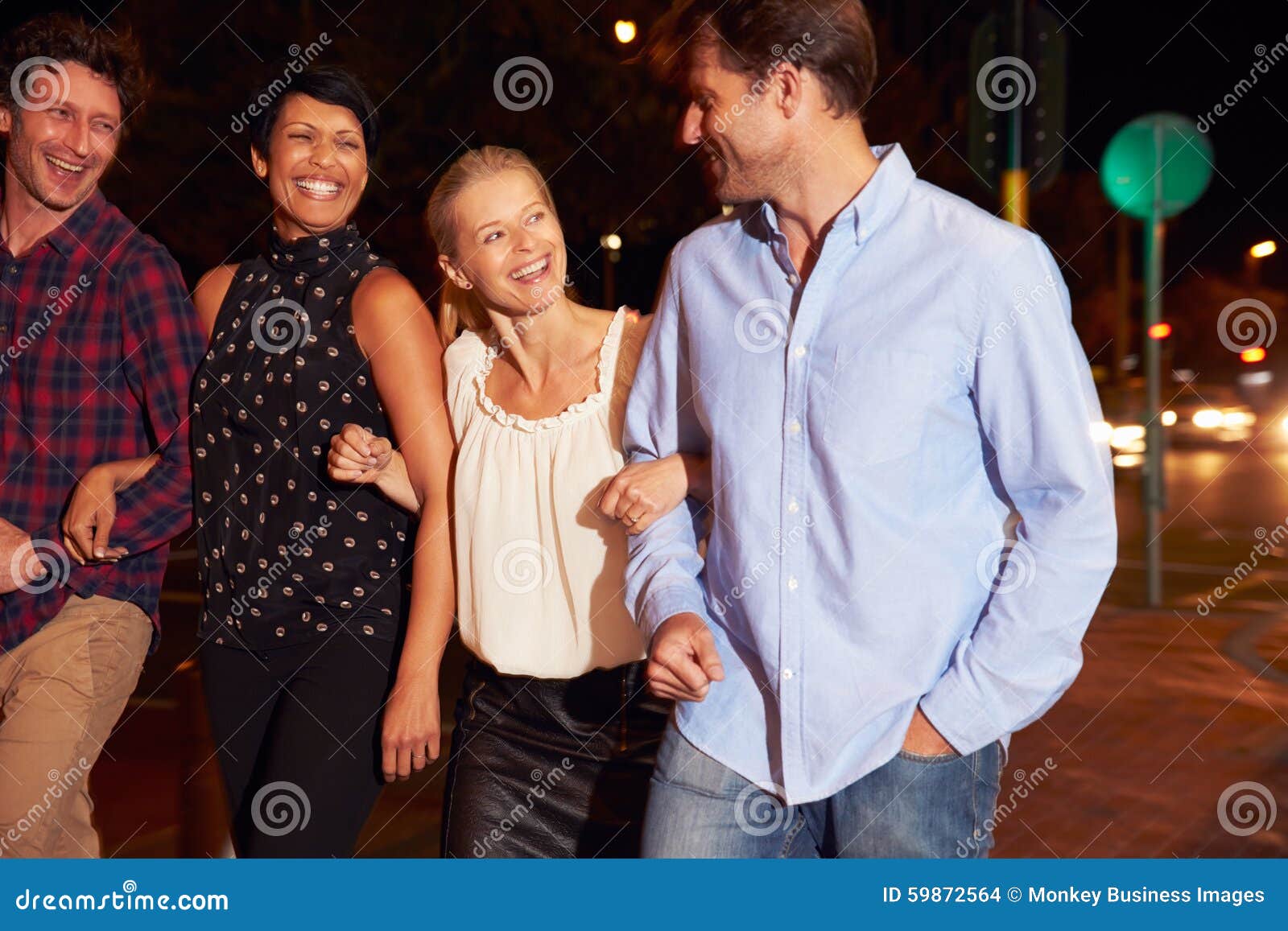 Four Friends Walking through Town Together at Night Stock Photo - Image ...
