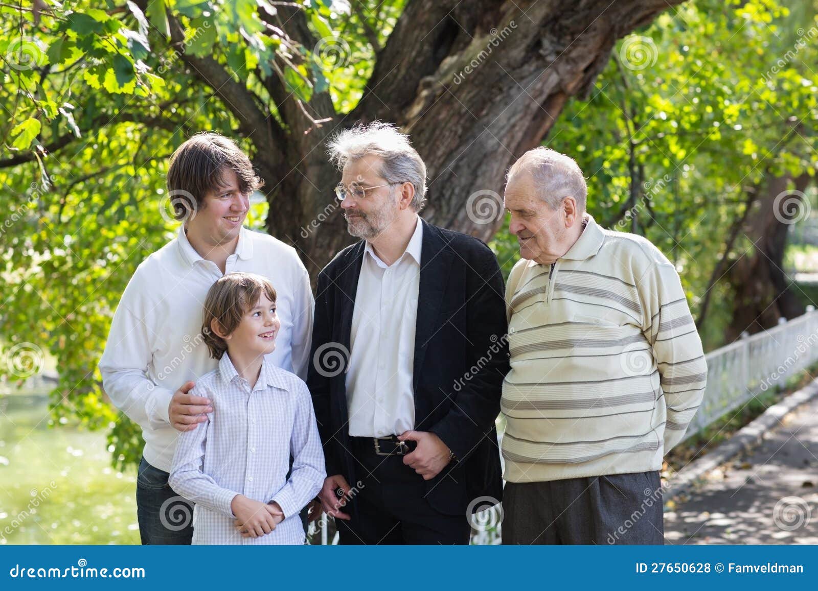 Four Generations of Men Standing in a Park Looking at Each Other and ...